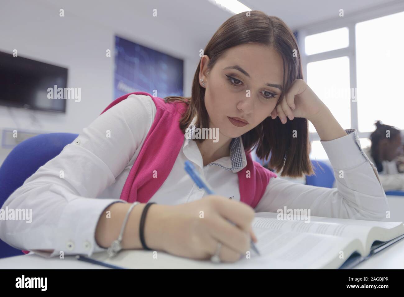 Beautiful femele student taking notes in the classroom Stock Photo - Alamy