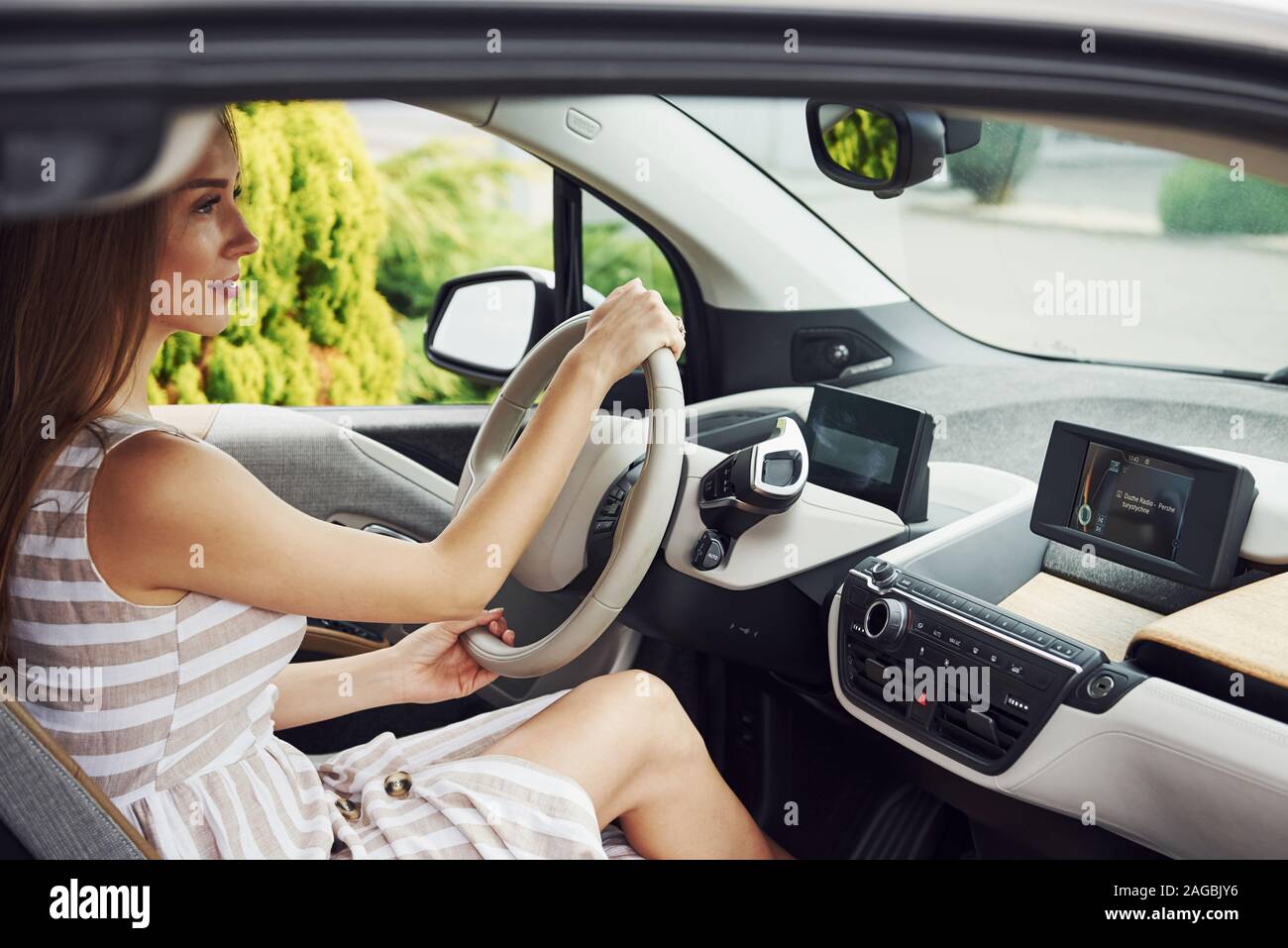 Side view. Female driver inside of modern automobile. Testing brand new ...