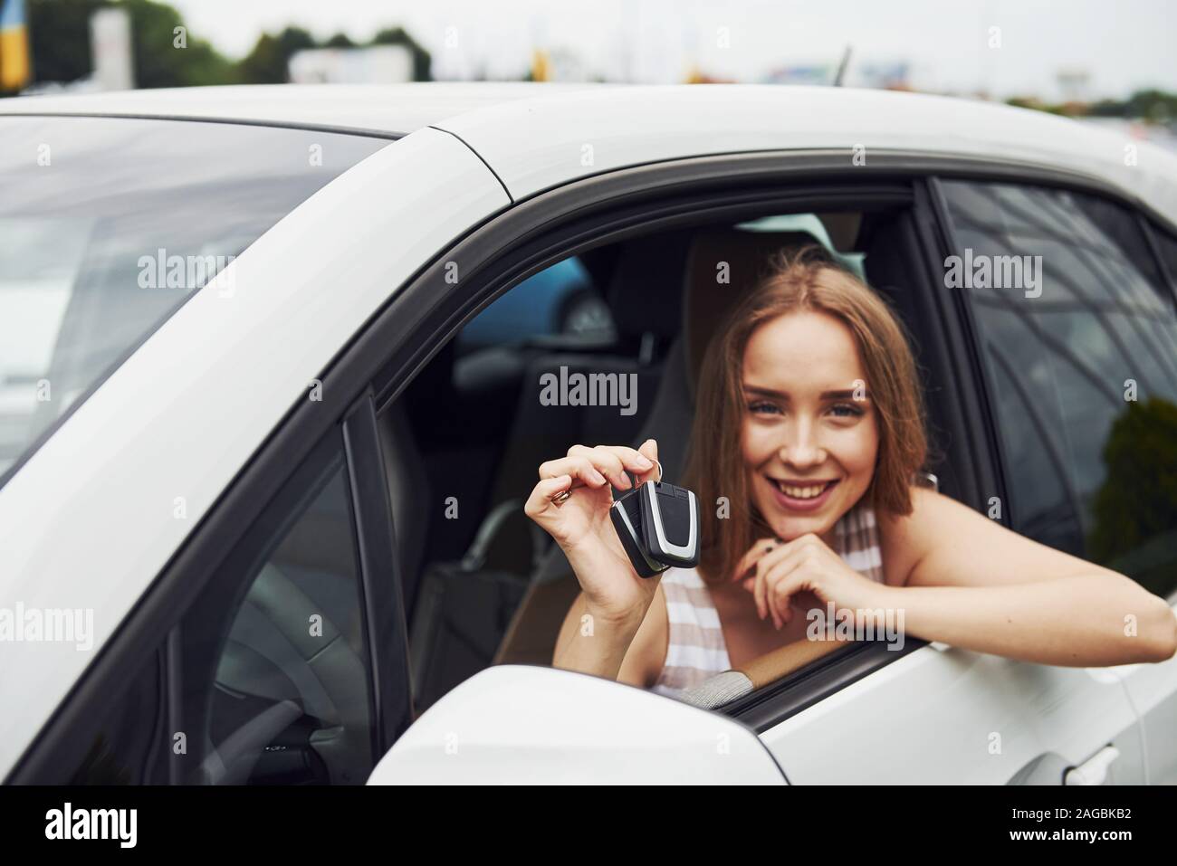 Feeling happy. Female driver showing her keys while sits inside of ...