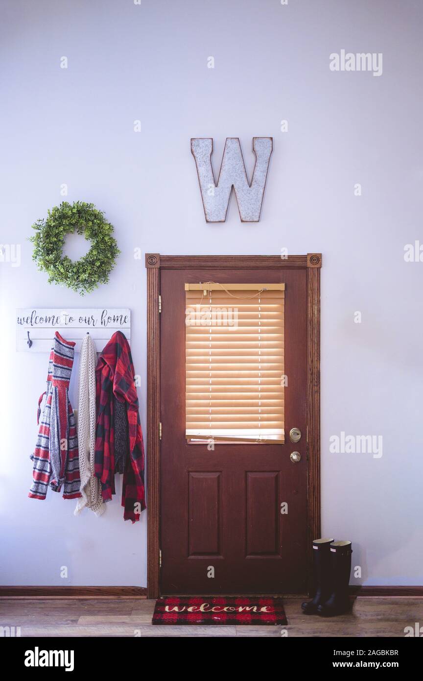 Vertical shot of a door with welcoming words written on the door carpet ...