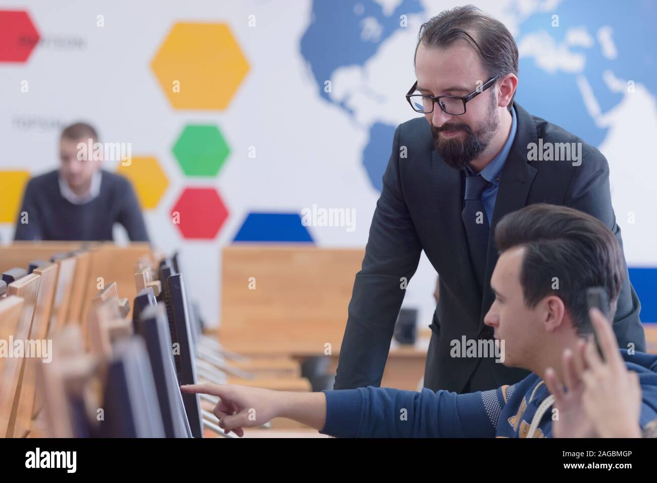 Group of students study with professor in modern school computer lab ...