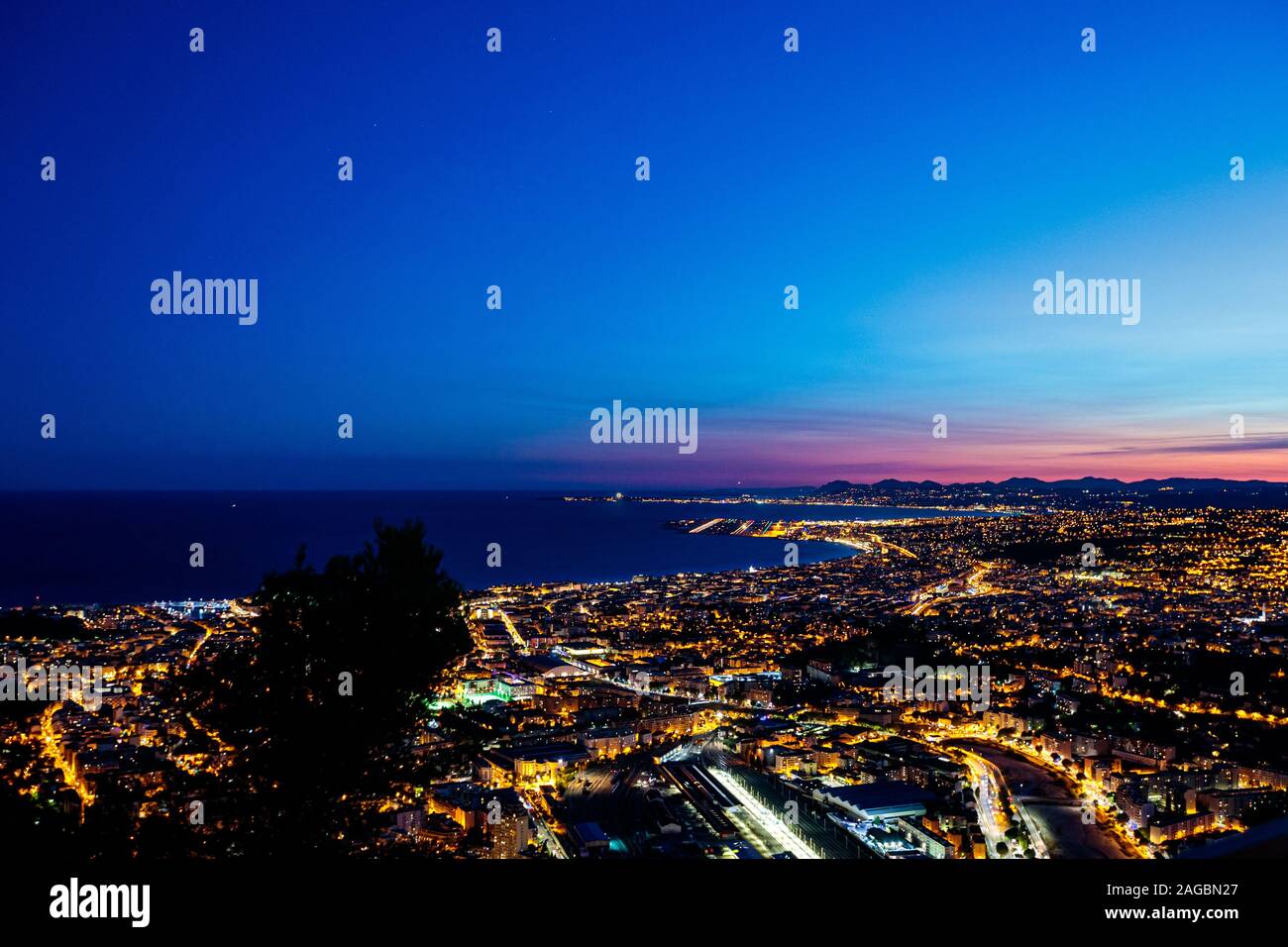 High angle shot of a beautifully illuminated cityscape and a sea in ...