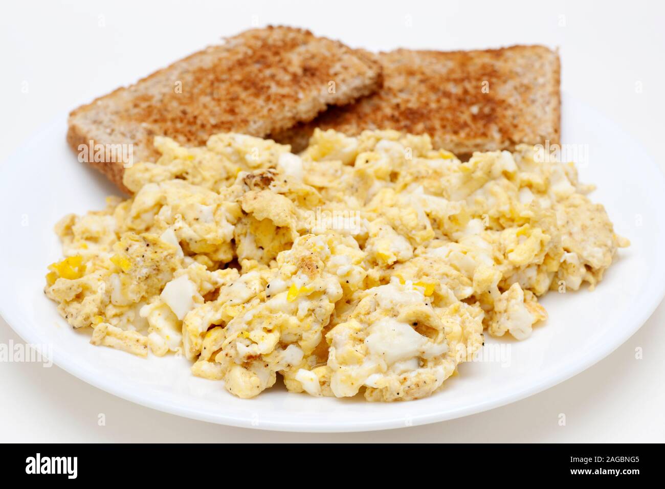 scrambled eggs and whole wheat toast on white plate, ready to eat Stock Photo - Alamy
