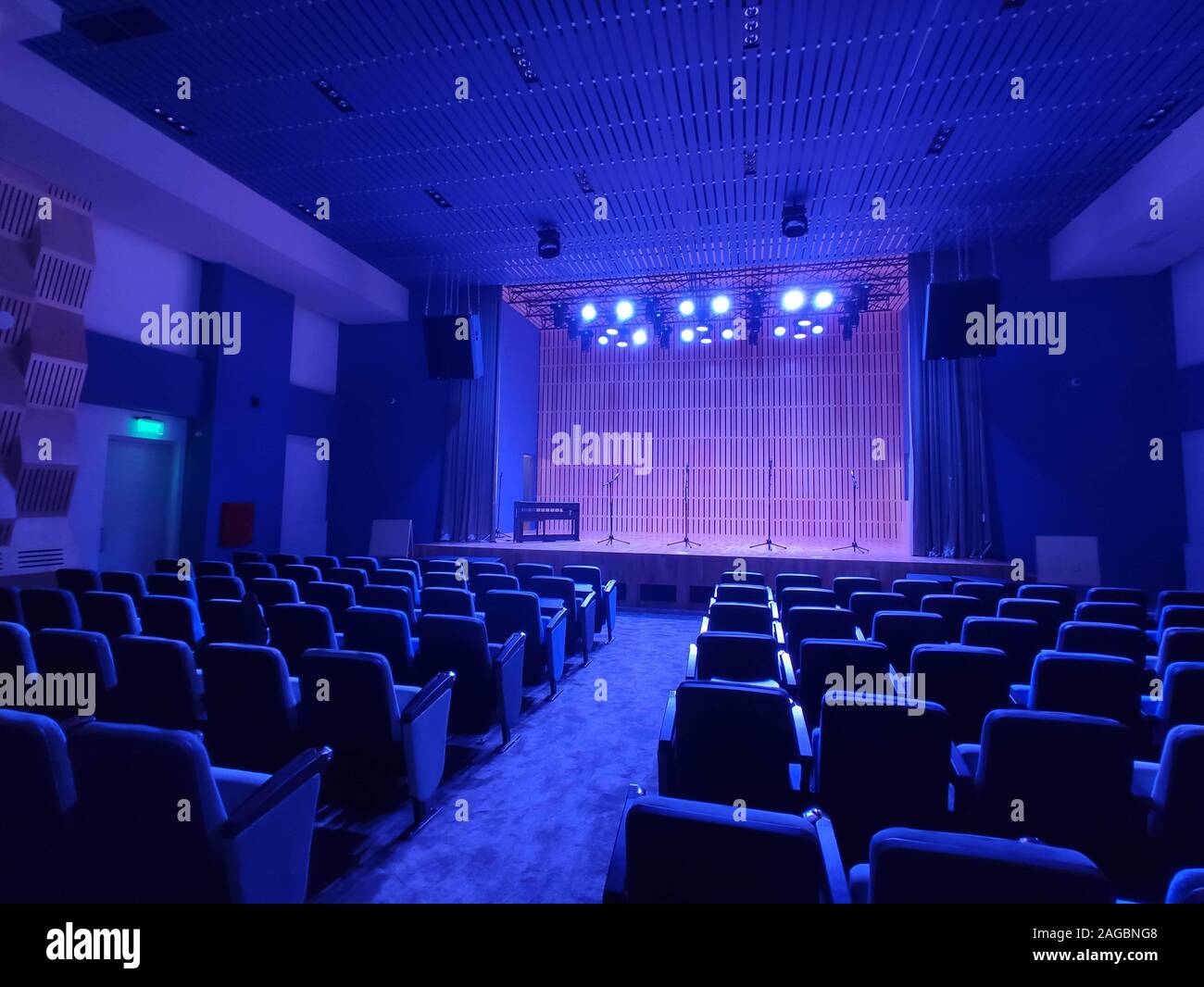 Inside shot of a small empty auditorium with four microphones on the ...