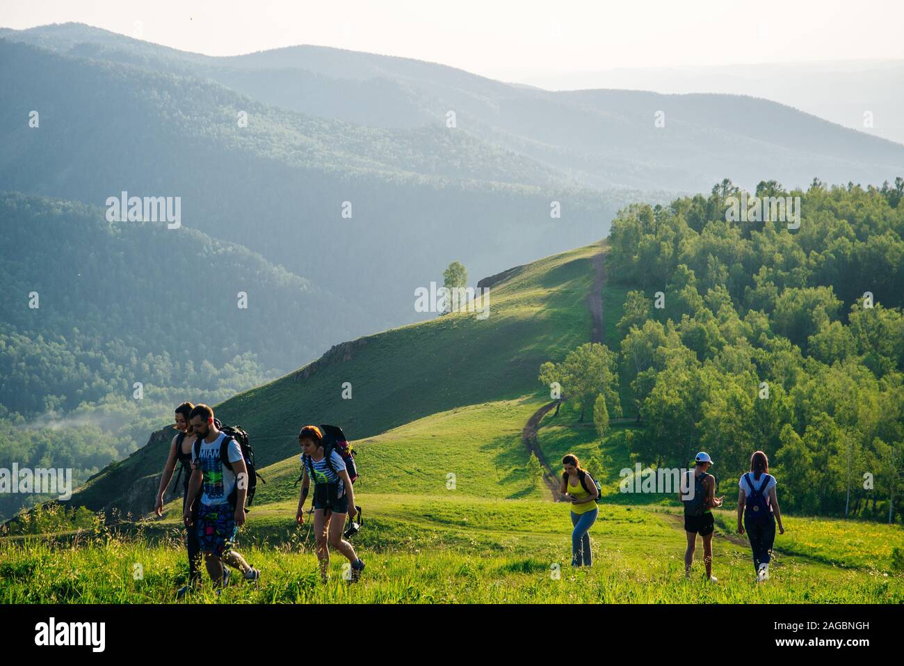 Russia, Krasnoyarsk - june, 2019 tourists go hiking through the green ...