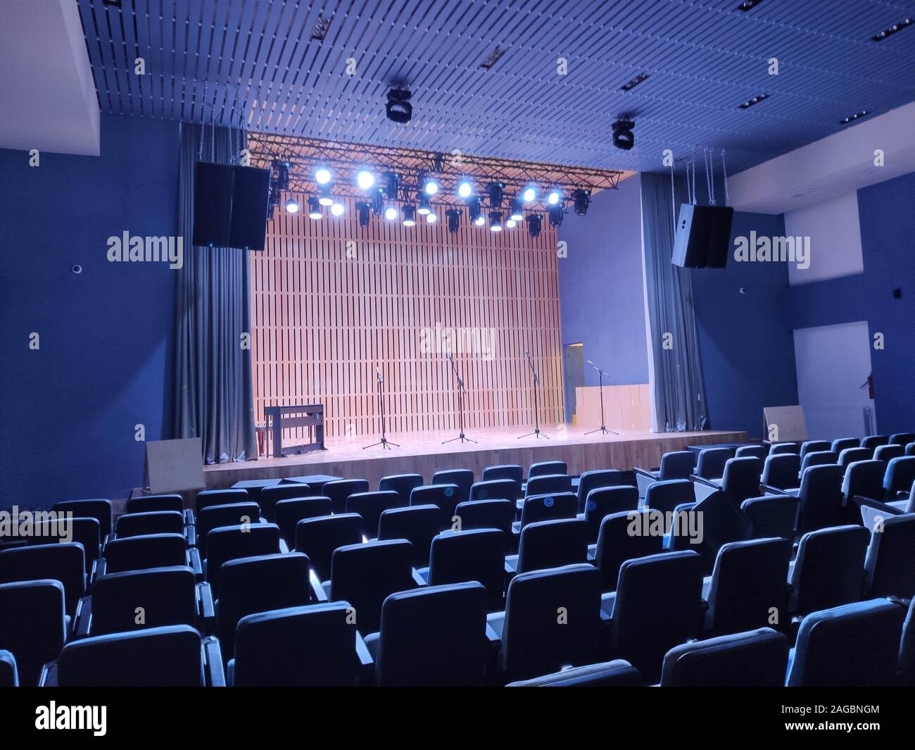 Inside shot of a small empty auditorium with four microphones on the ...
