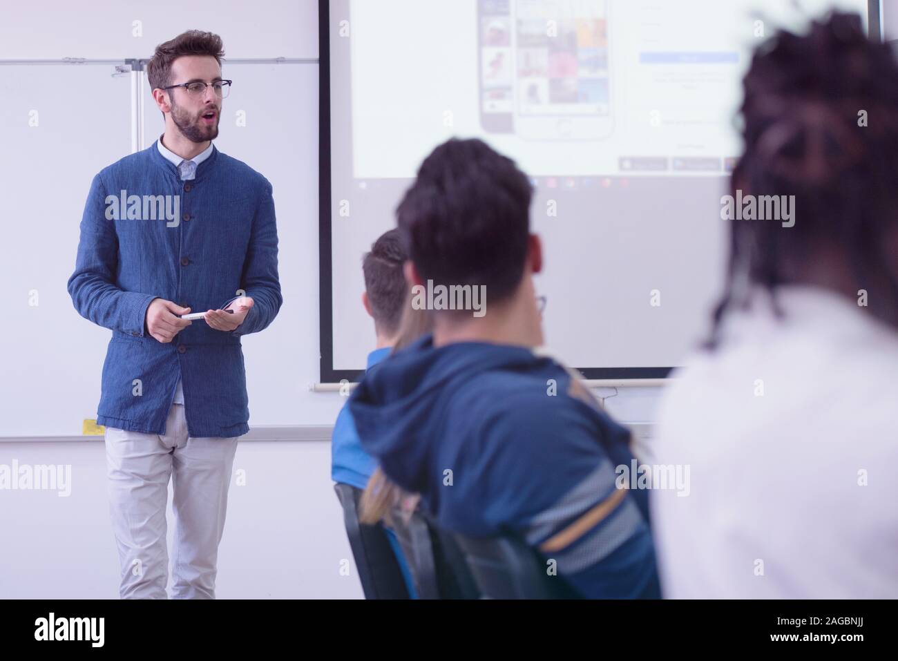 Group of students study with professor in modern school classroom. Male ...