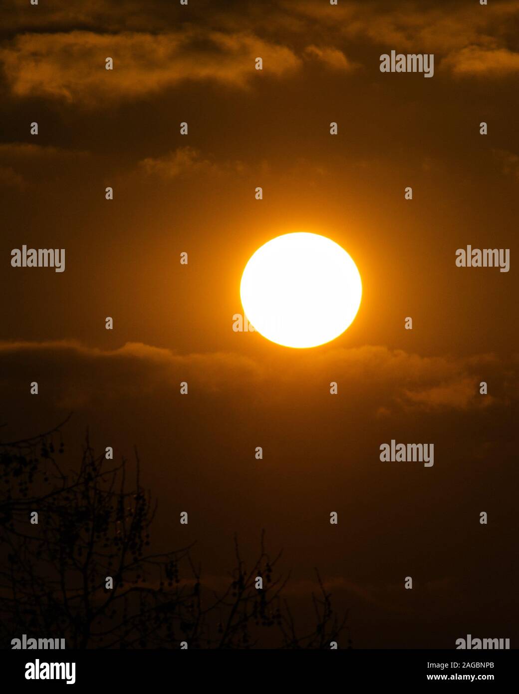 Stunning vertical shot of the bright sun at sunset above the beautiful ...