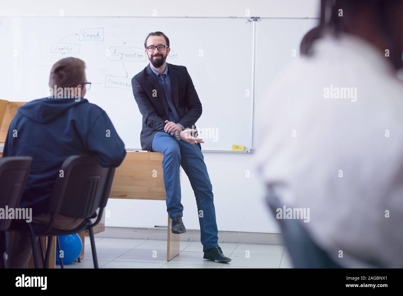 Group of students study with professor in modern school classroom. Male ...