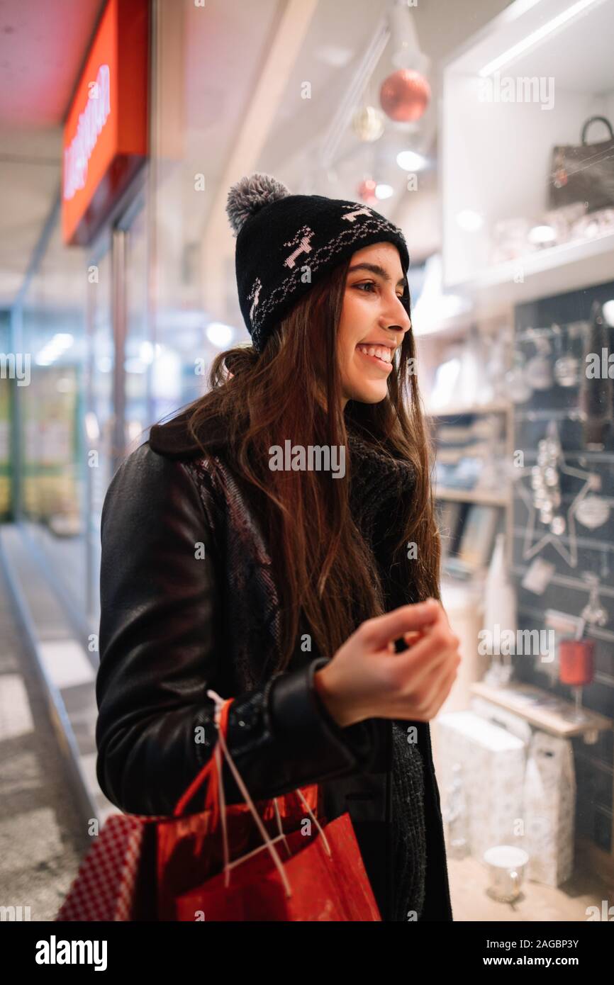Smiling girl standing in front of the shop window Stock Photo - Alamy