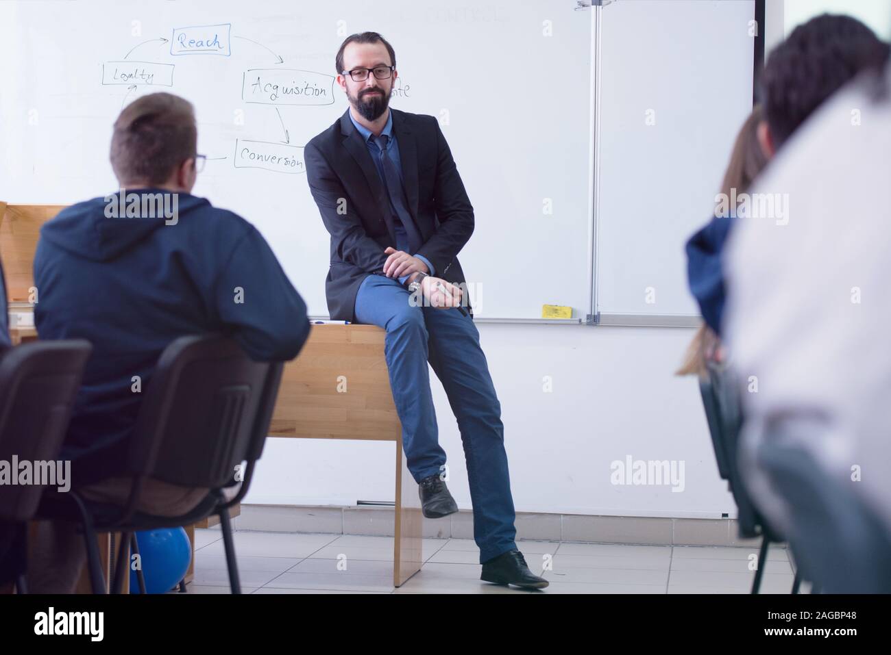 Group of students study with professor in modern school classroom. Male ...