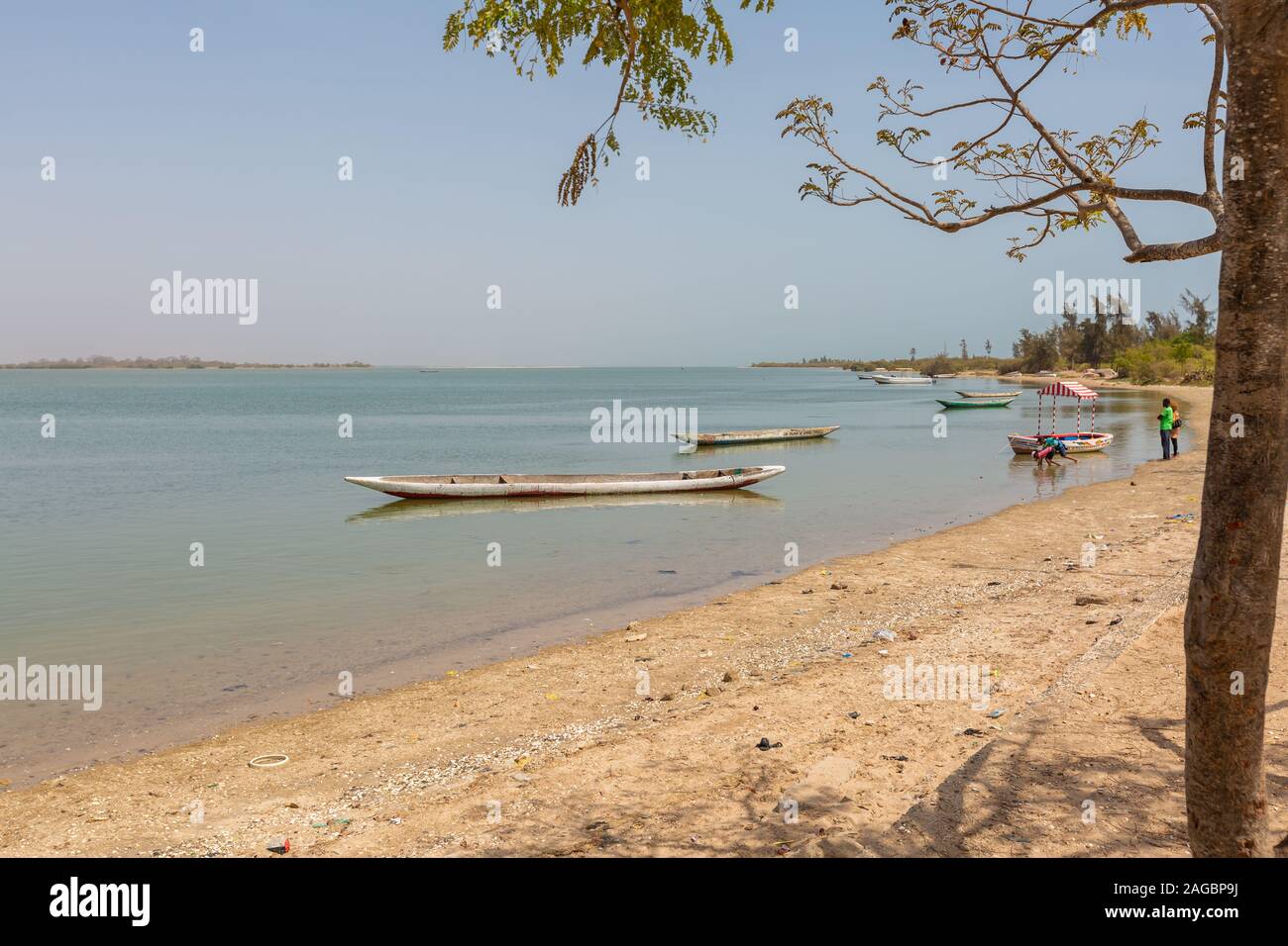 Landscape of a sea and wooden boats surrounded by beaches and greenery ...