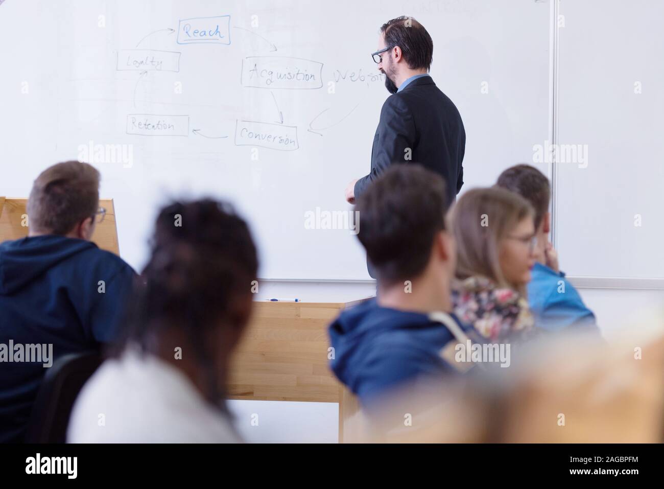Group of students study with professor in modern school classroom. Male ...