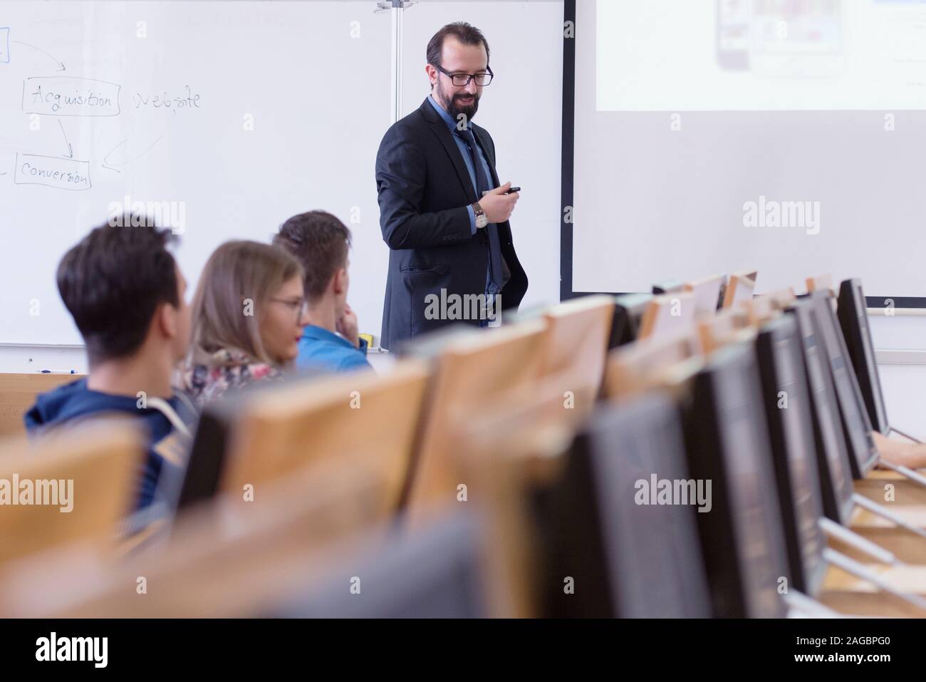 Group of students study with professor in modern school classroom. Male ...
