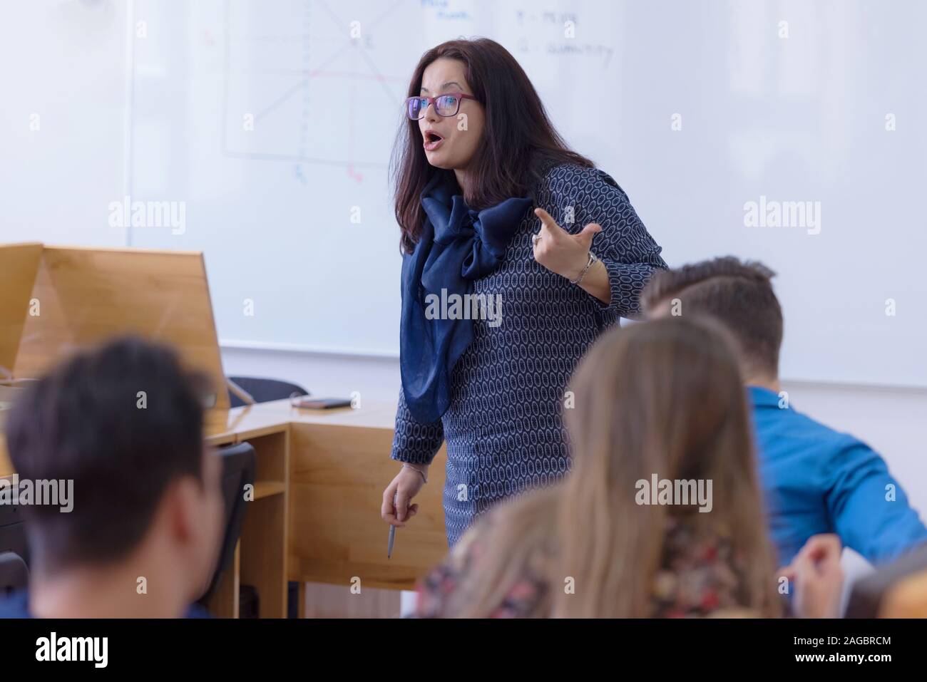 Female professor explain to students and interact with them in the ...