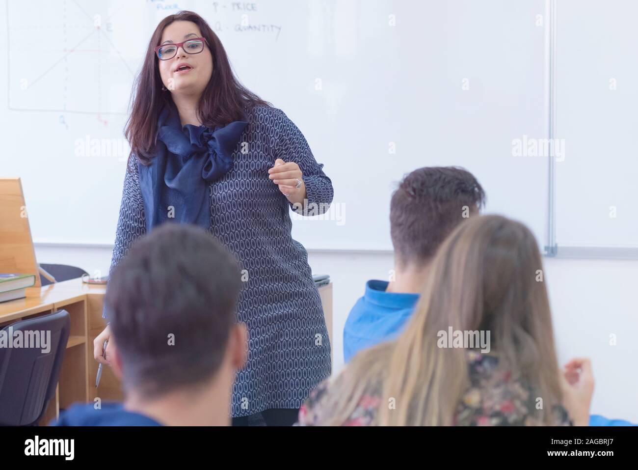 Female professor explain to students and interact with them in the ...
