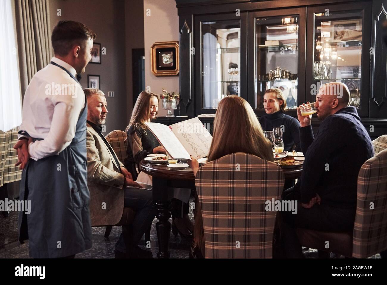 Waiter is waiting for an order. Family friends having nice time in ...