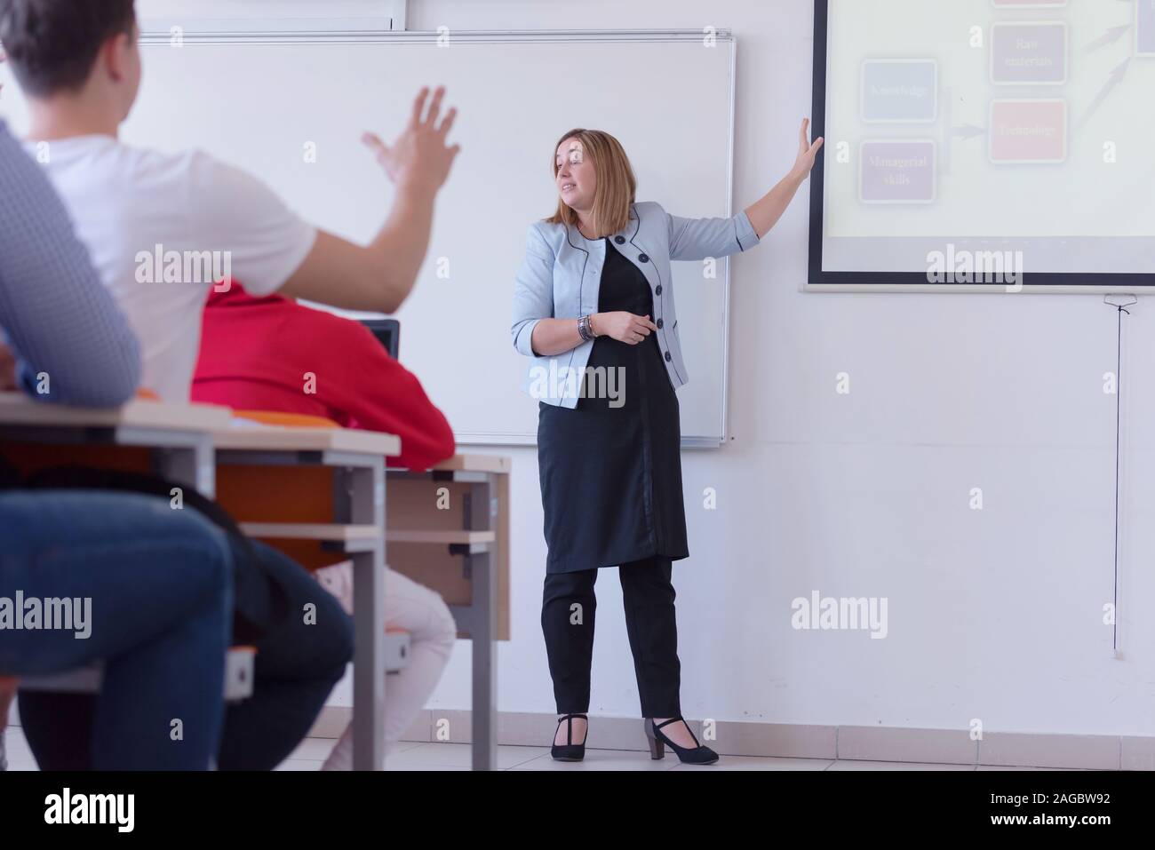 Female professor explain to students and interact with them in the ...
