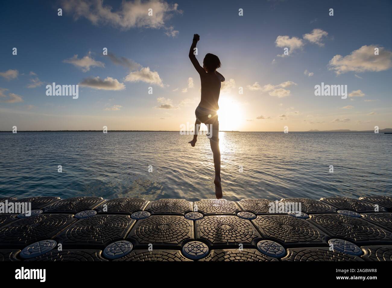 Person enjoying freedom jumping in the ocean during sunrise in Bonaire ...