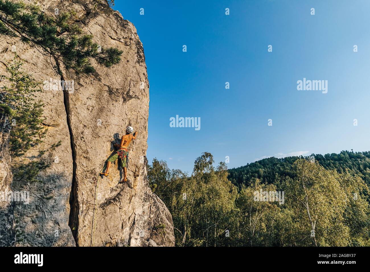 Mountain climber climbing the cliff using his climbing equipment Stock ...