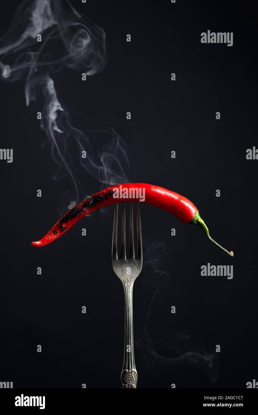 Hot chili red pepper smoking on a fork. Spice concept. Copy space Stock ...