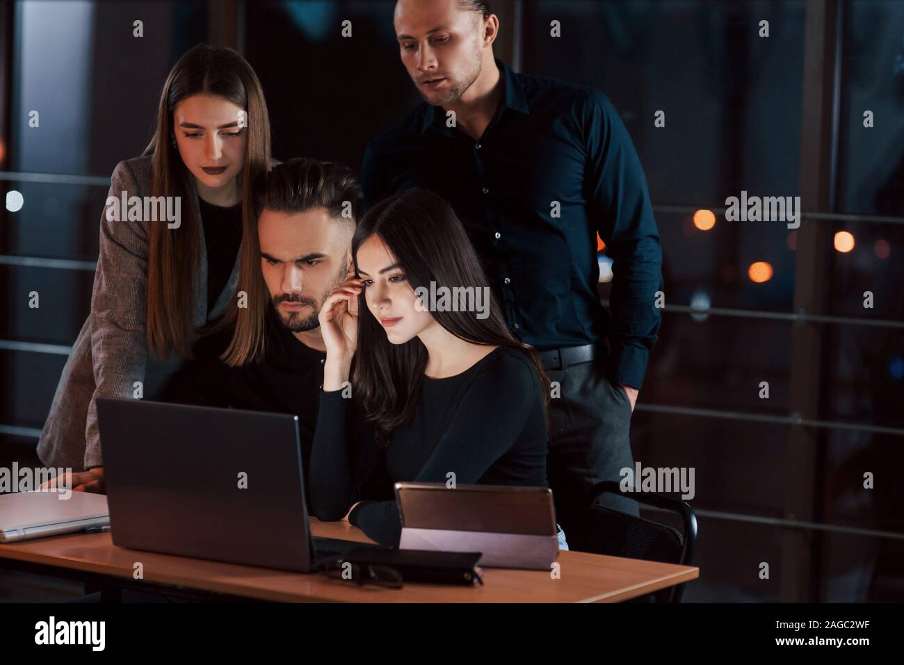 Four employees. Team of young business people works on their project at ...