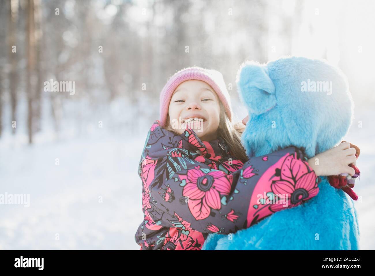 Closeup shot of a naturally smiling little girl in the arms of a female ...