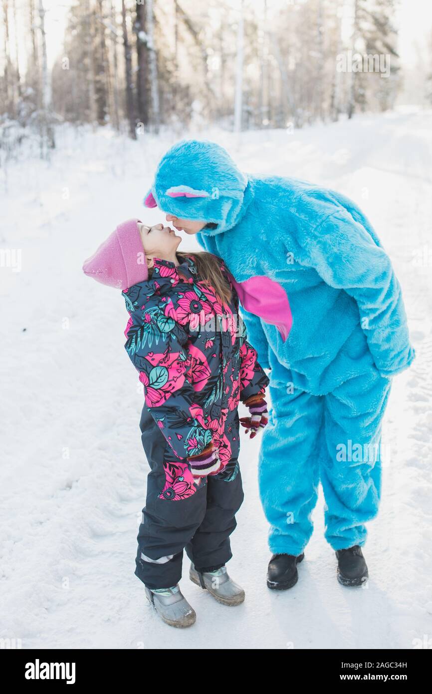 Vertical closeup shot of a cute little girl kissing a female in a ...