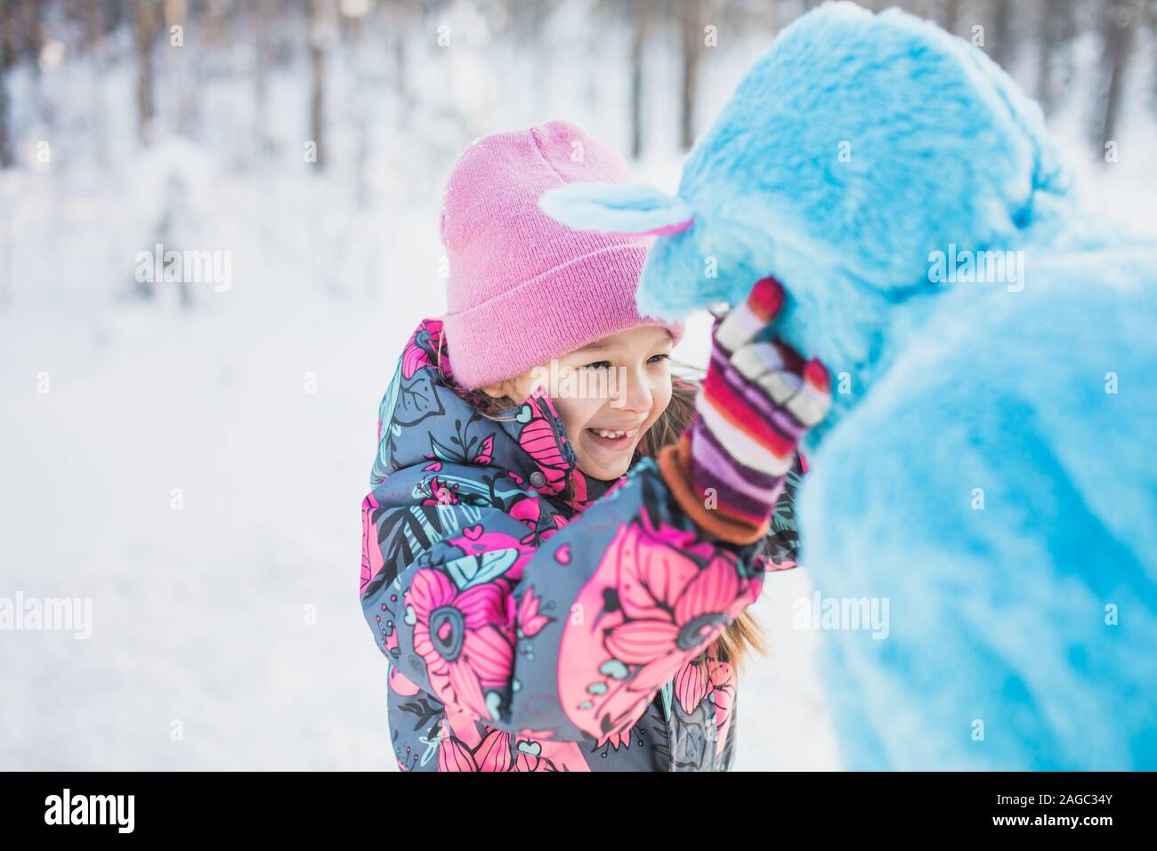 Closeup shot of a happy little girl pinching the cheeks of a female in ...