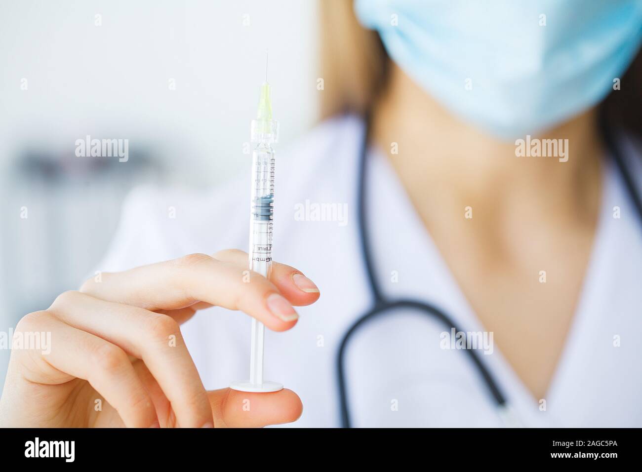Female doctor or physician holding hypodermic syringe with injection ...