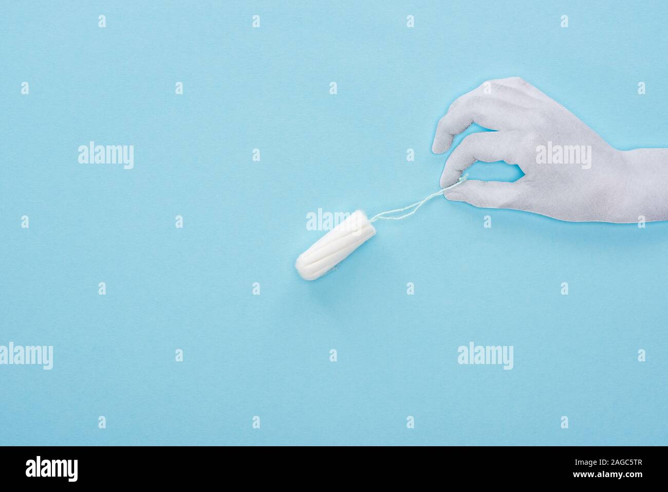 top view of white paper hand and cotton tampon on blue background Stock ...
