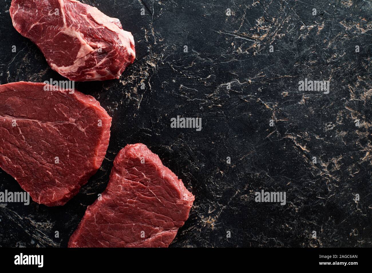 top view of raw beef parts on black marble surface Stock Photo - Alamy