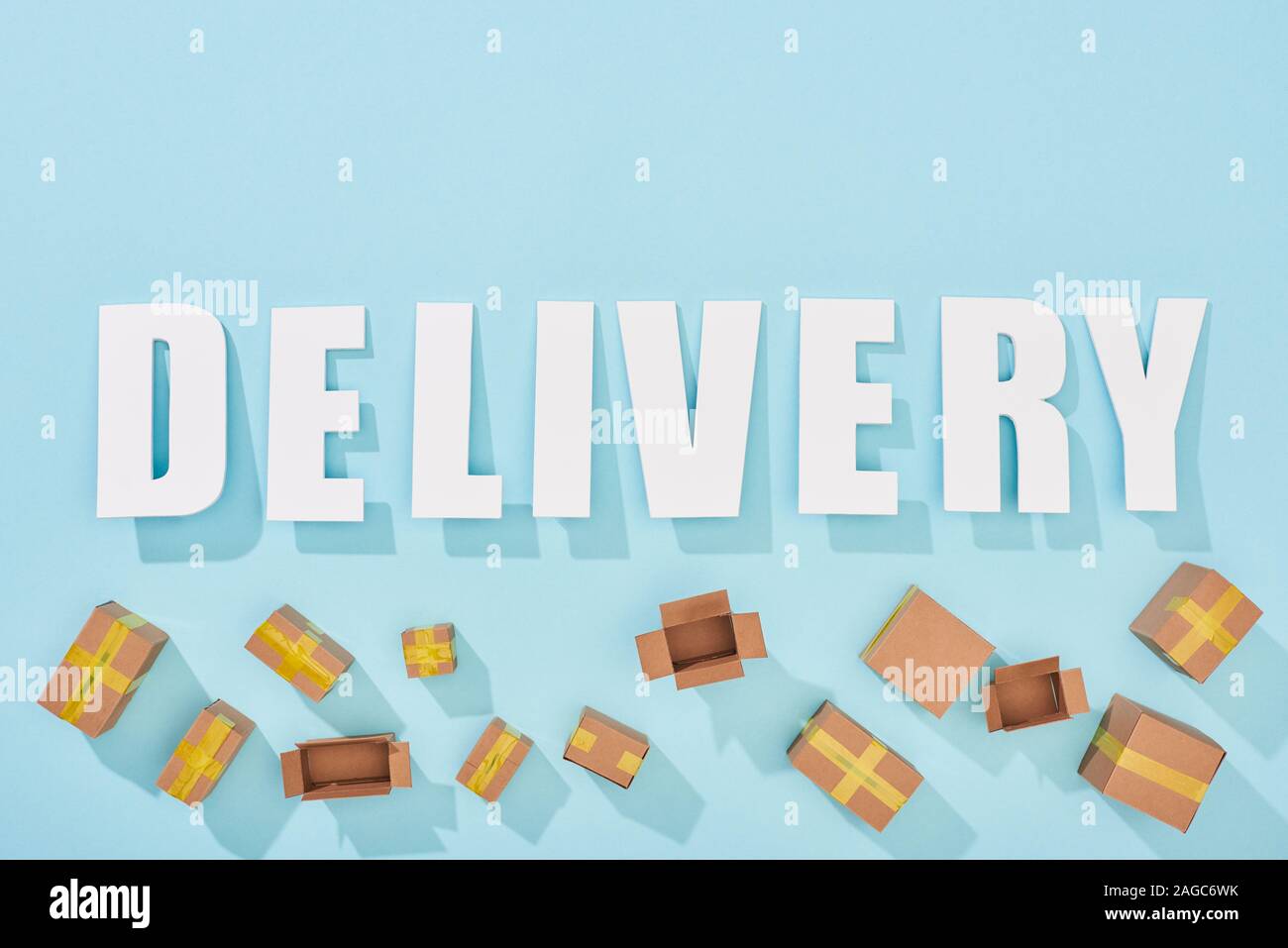 top view of white word delivery near open and closed cardboard boxes on ...