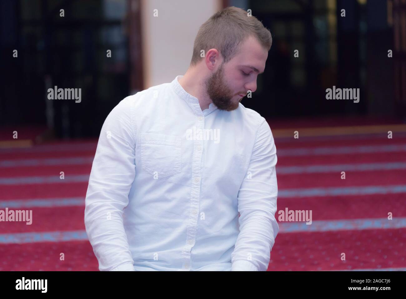 Young religious european muslim man praying inside the beautiful big ...