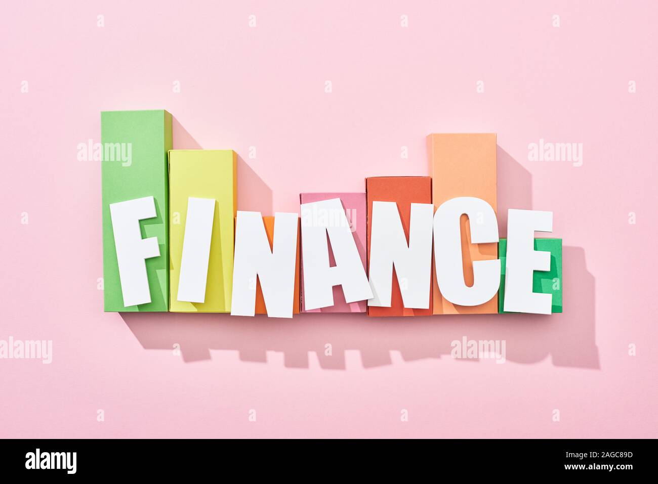 top view of finance inscription on pink background with color block ...