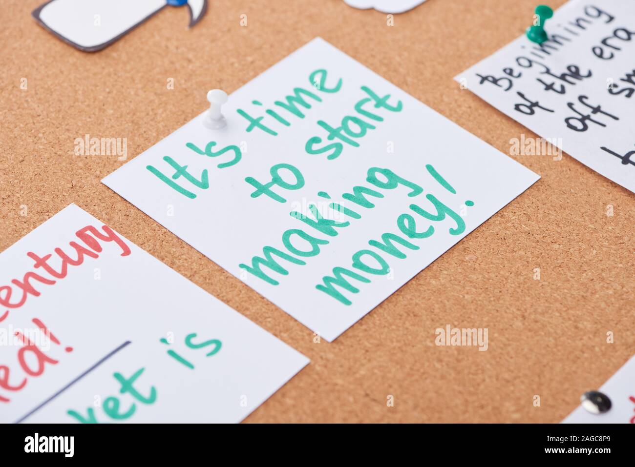 paper card with work motivation message pinned on cork office board ...