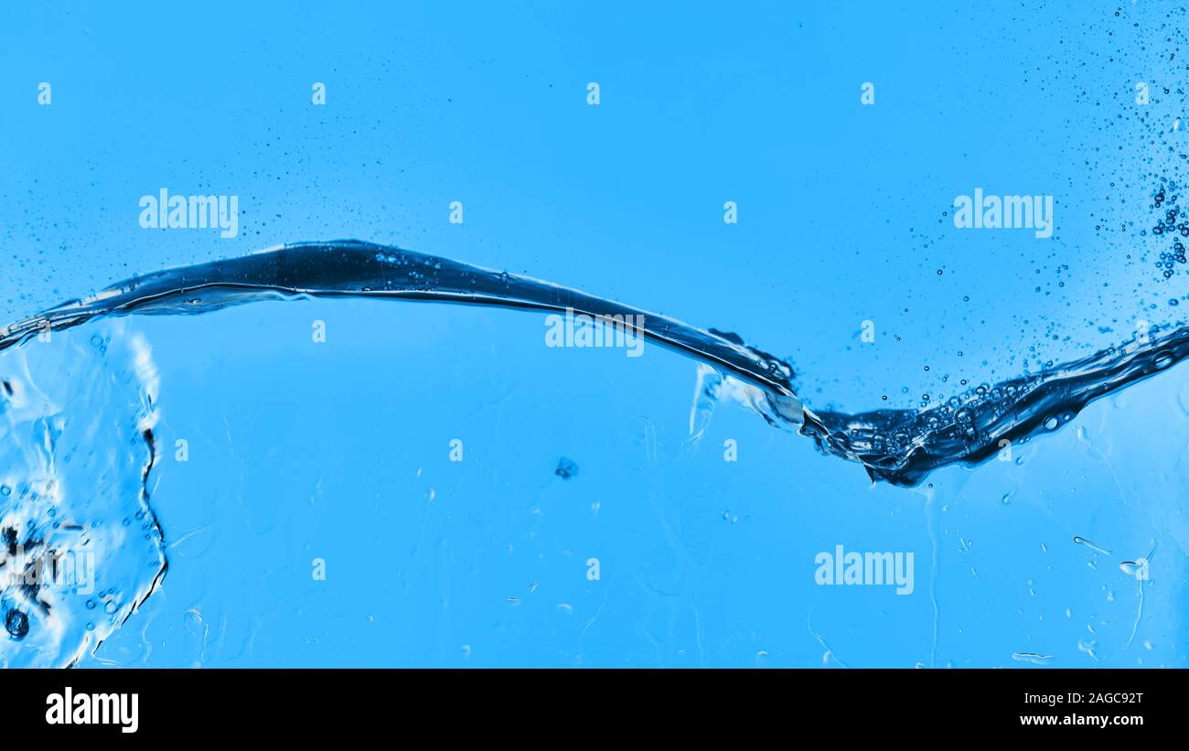 wavy transparent water on blue background with droplets and splash ...