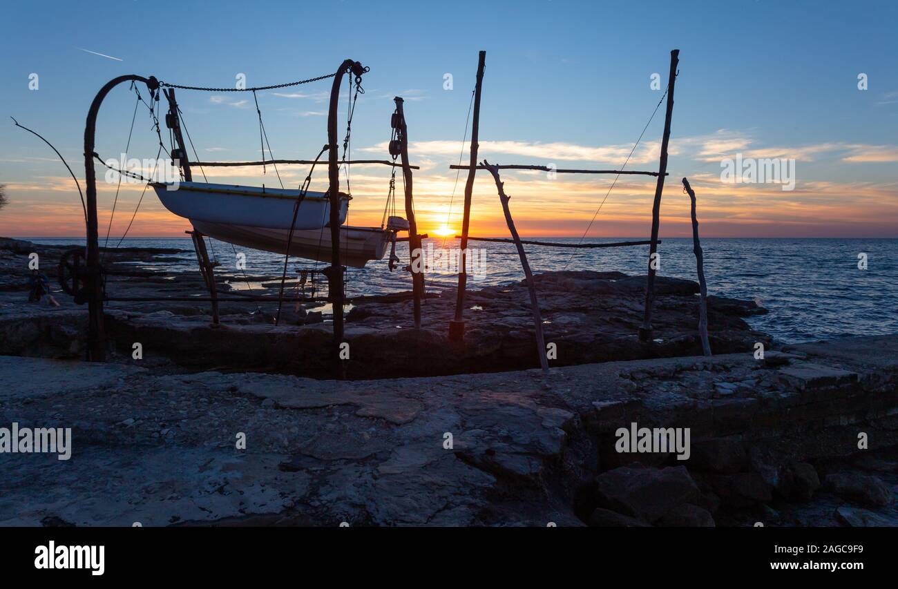 Fishing boats hanged above the rock formations at the coast of the ...