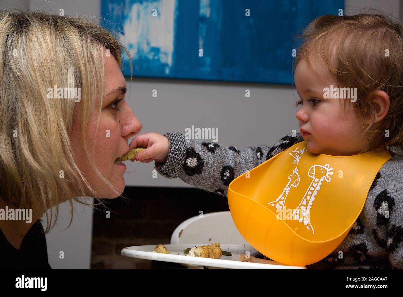 Toddler girl eating first foods UK Stock Photo - Alamy