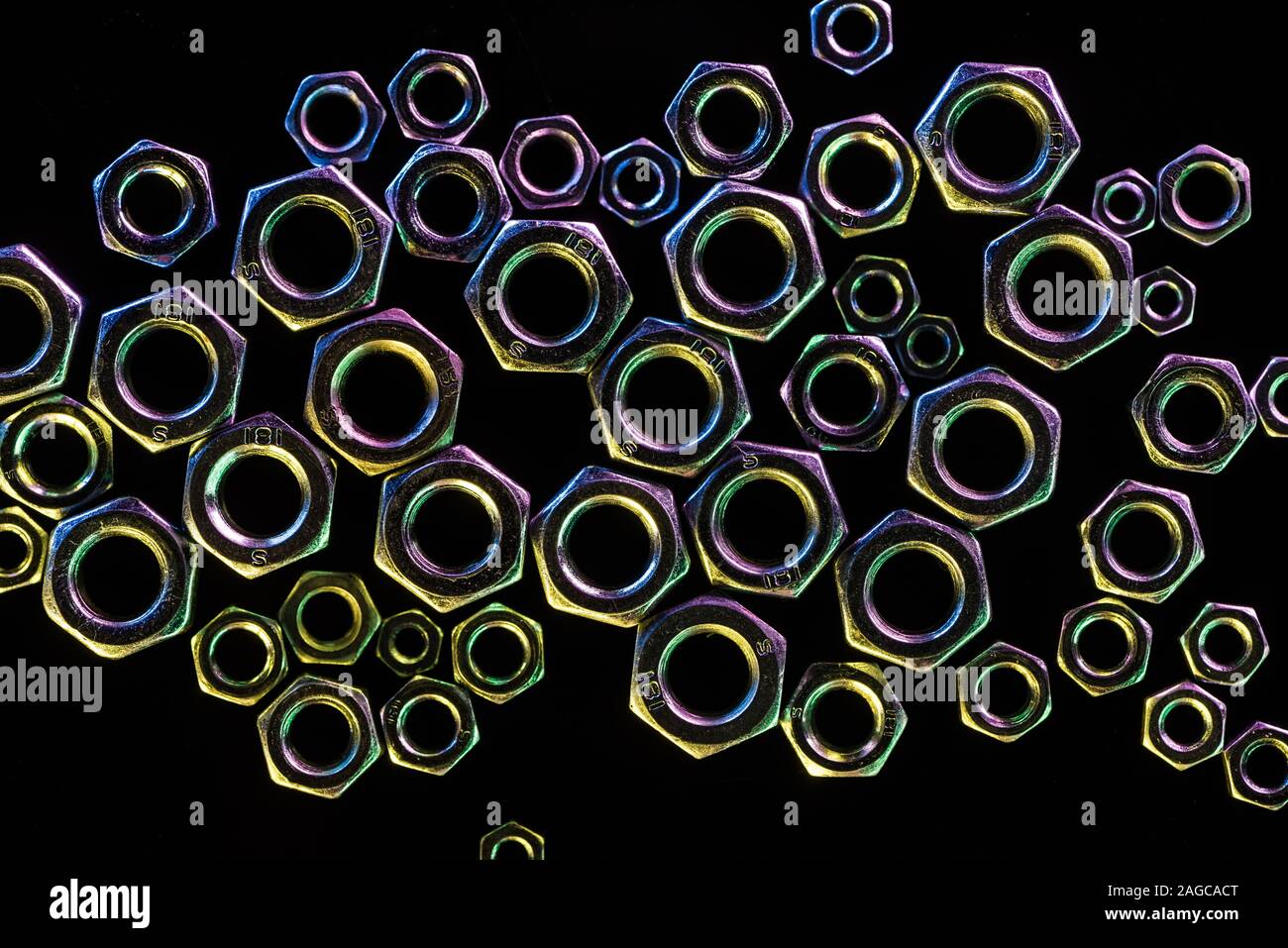 top view of scattered shiny metal nuts isolated on black Stock Photo ...