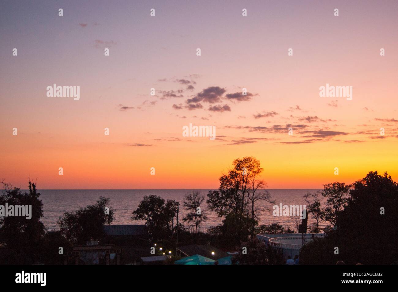 Sunset over the sea - view of a pink sky with purple clouds and ...