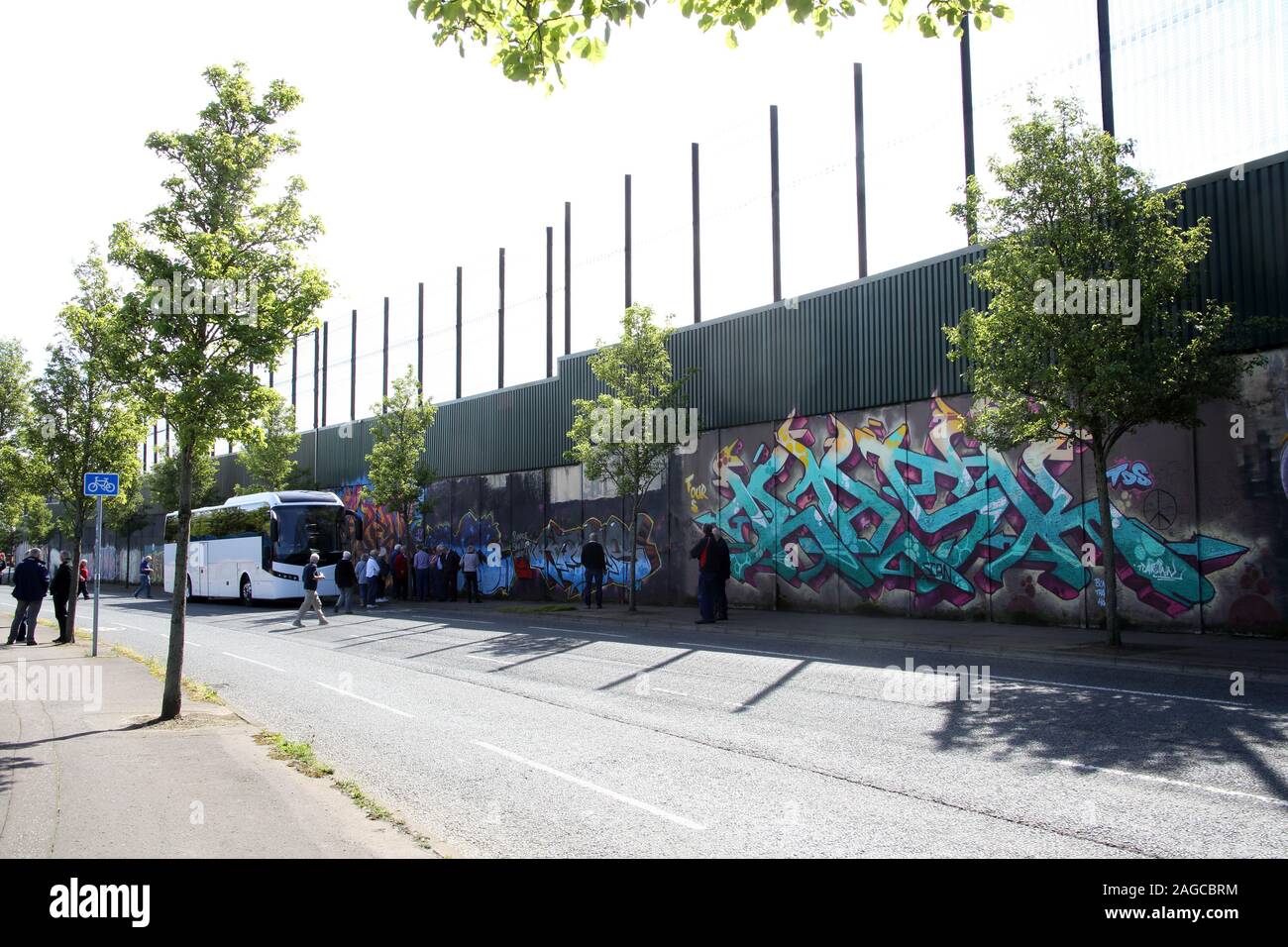 Tourists visiting the colourful murals and graffiti on the Peace wall ...