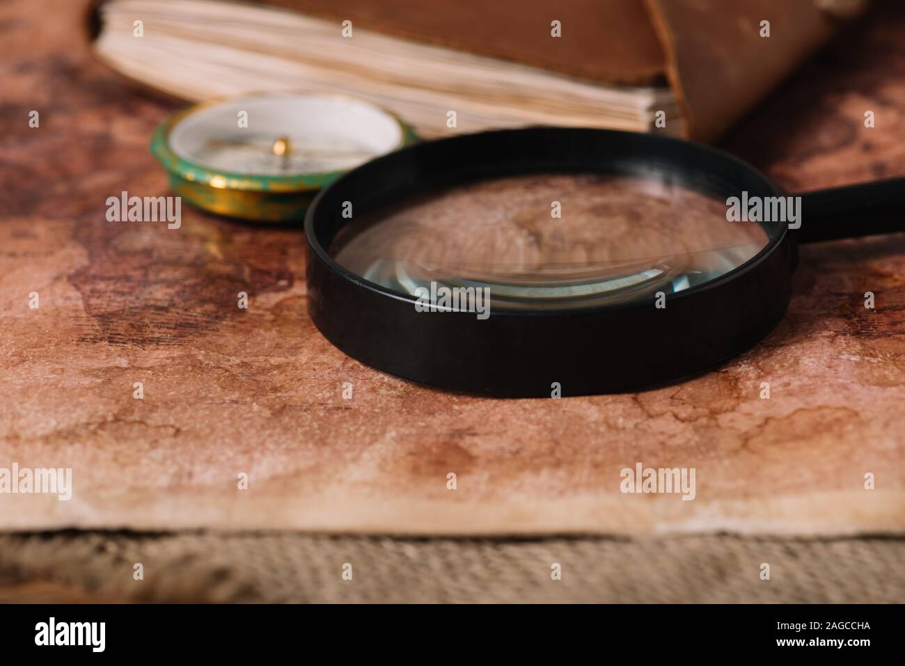 close up view of magnifying glass near compass on aged world map Stock ...