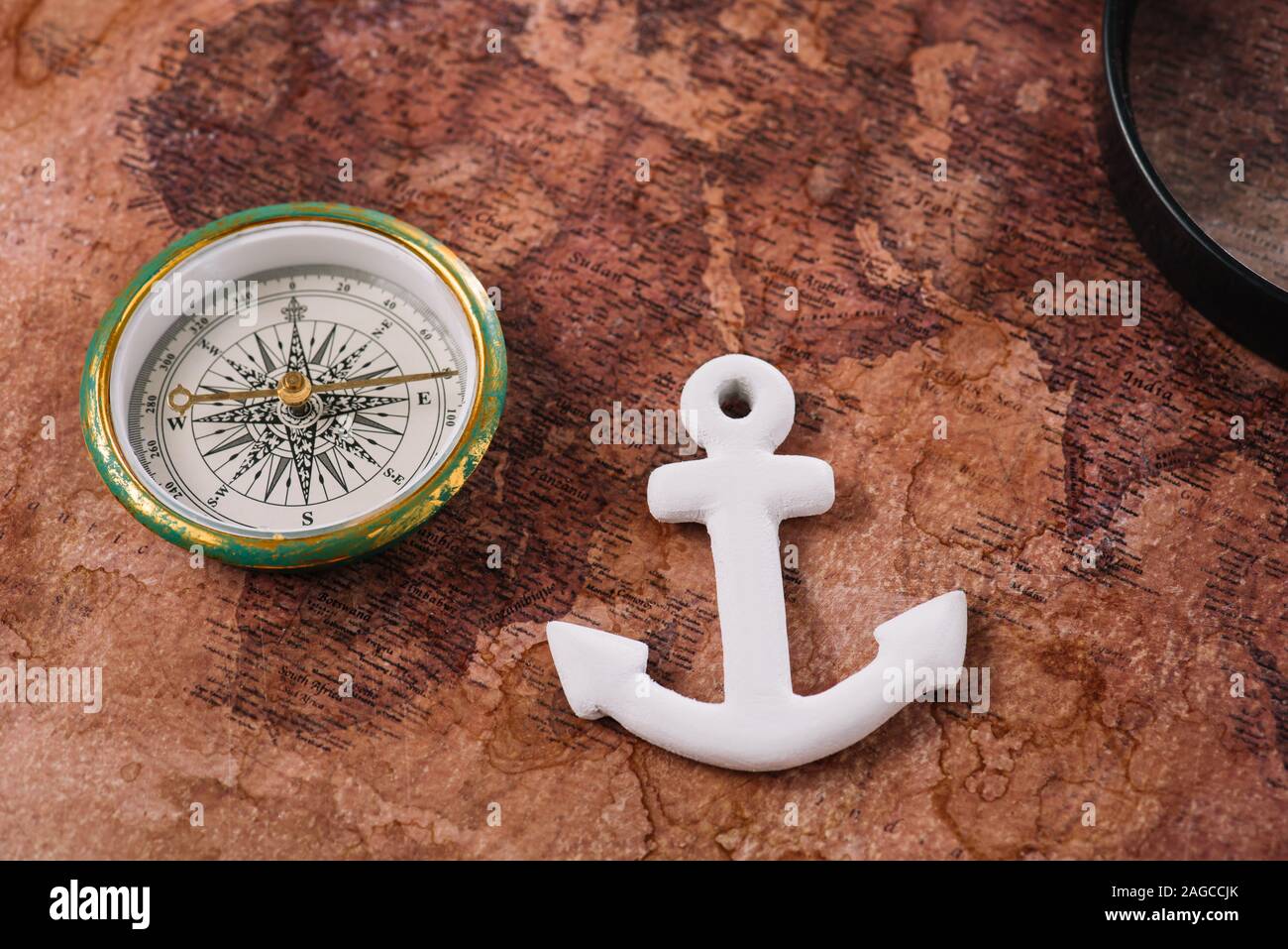 white anchor near compass on old world map Stock Photo - Alamy
