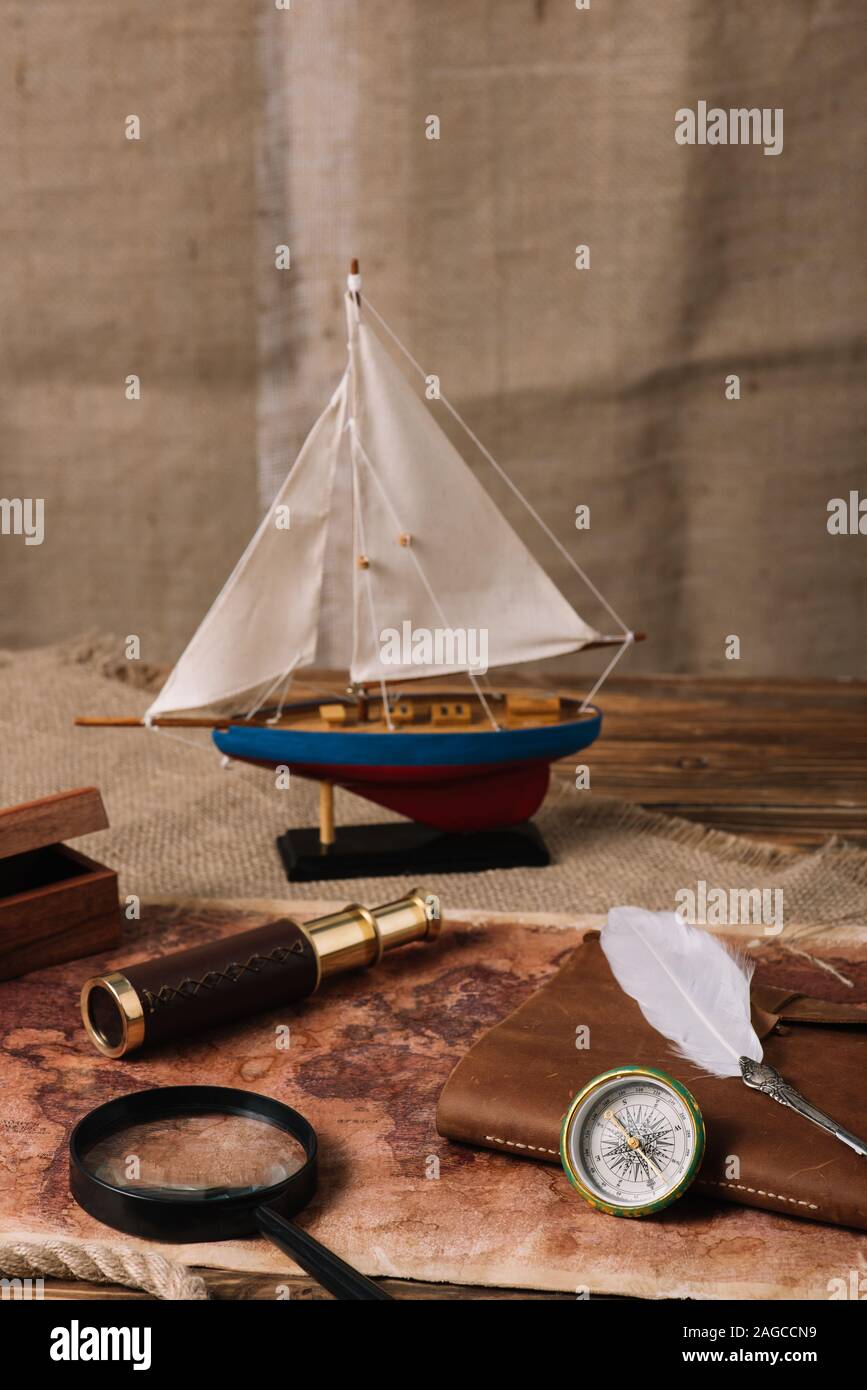 miniature ship, telescope, magnifying glass, leather copy book, compass ...