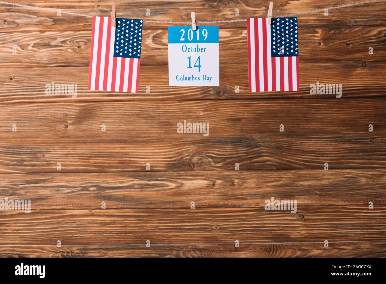 calendar with 14 October date between American national flags on wooden ...