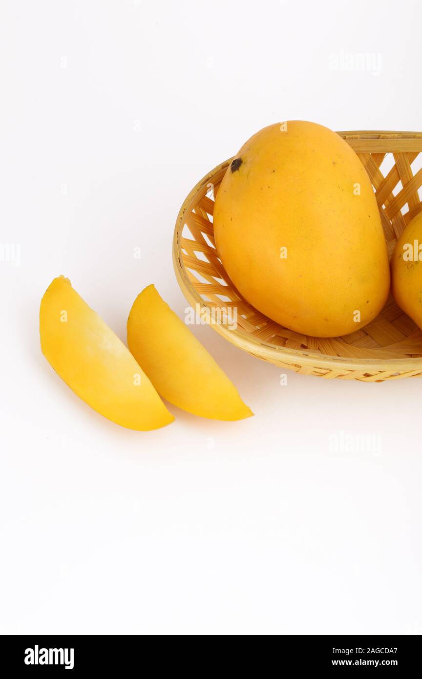 Mango fruit in basket with slice on white background Stock Photo - Alamy