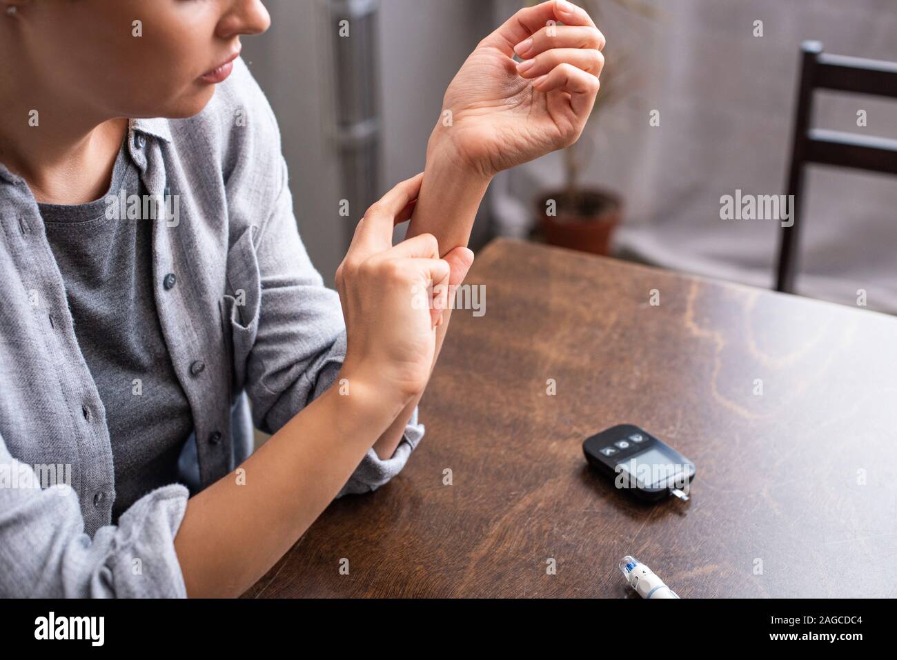 cropped view of woman checking pulse near table Stock Photo - Alamy
