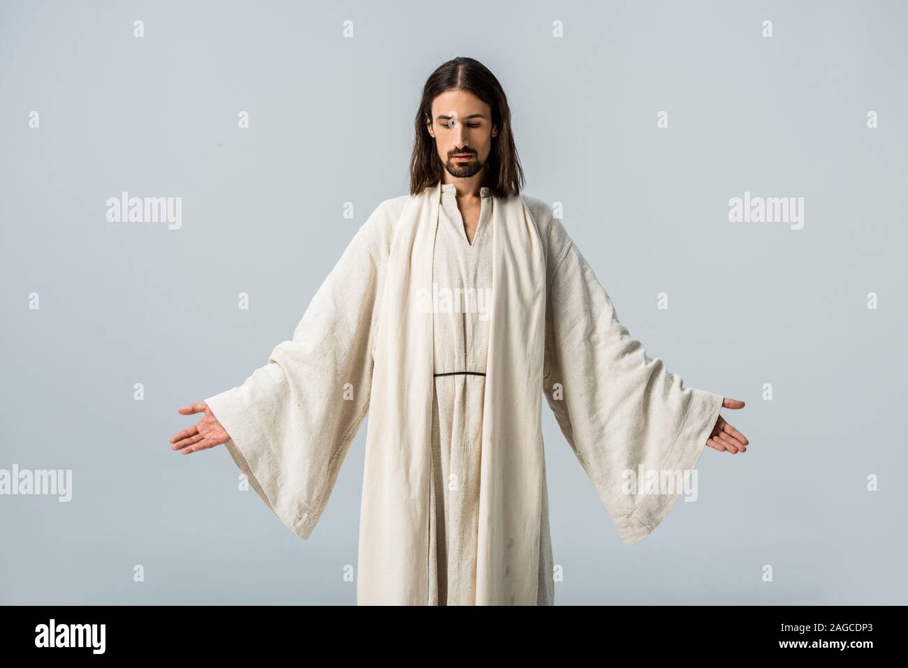 man in jesus robe standing with outstretched hands isolated on grey ...