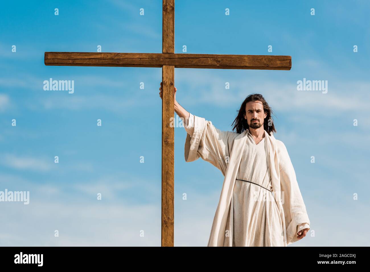 handsome man standing and holding wooden cross Stock Photo - Alamy